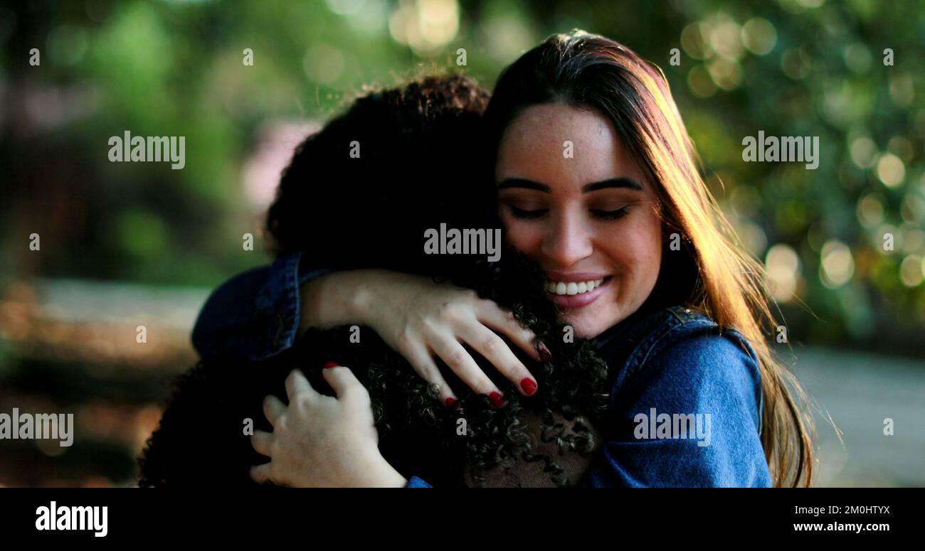 Empathic woman hugging friend outside Stock Photo - Alamy