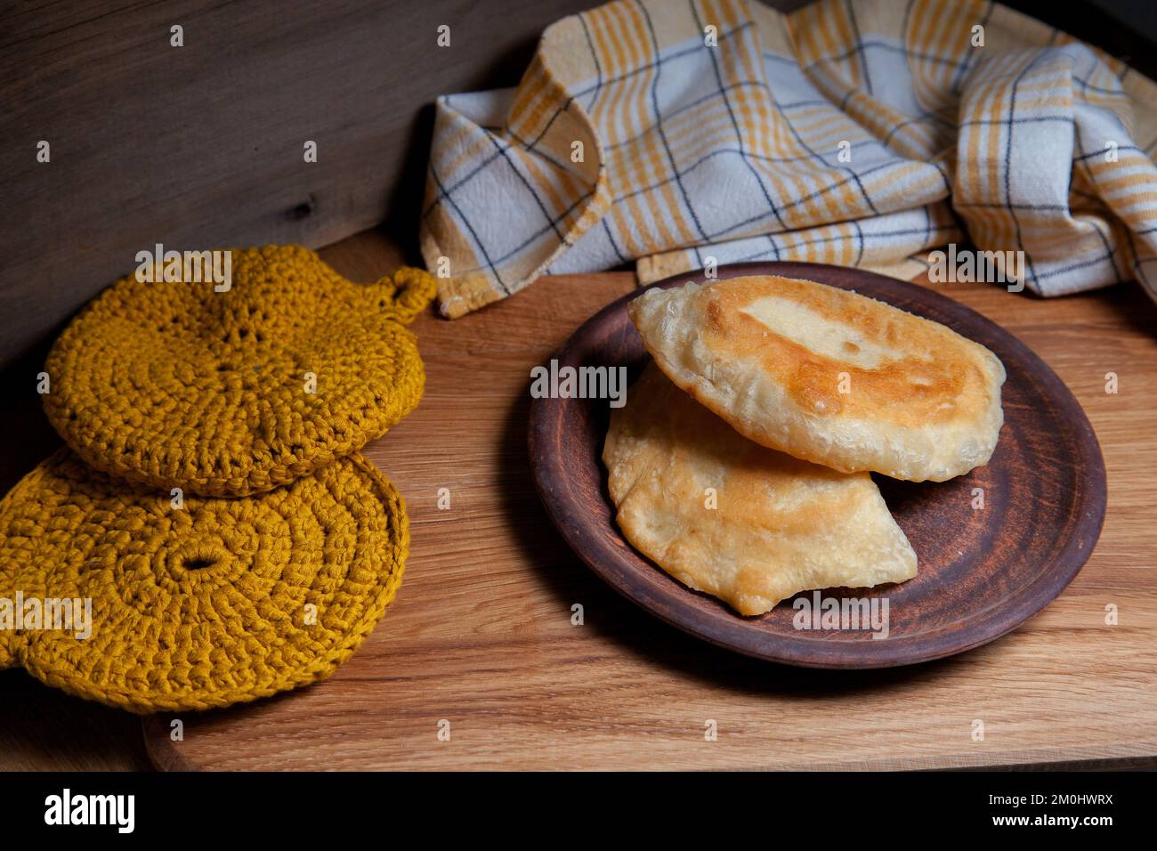 Clay plate with two of individual fried pies with meat on wooden table ...