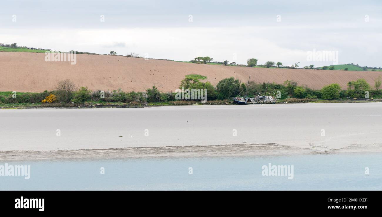 Seaside landscape and a farmer's field on a hill. Sandy seashore on a ...