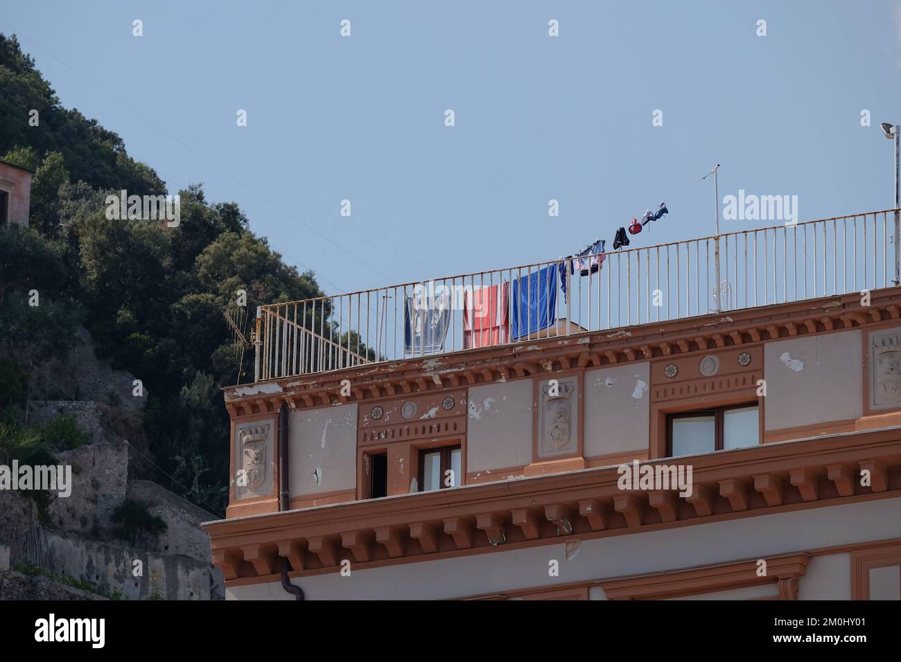 Beach attire and towels drying on a line on a traditional roof balcony ...