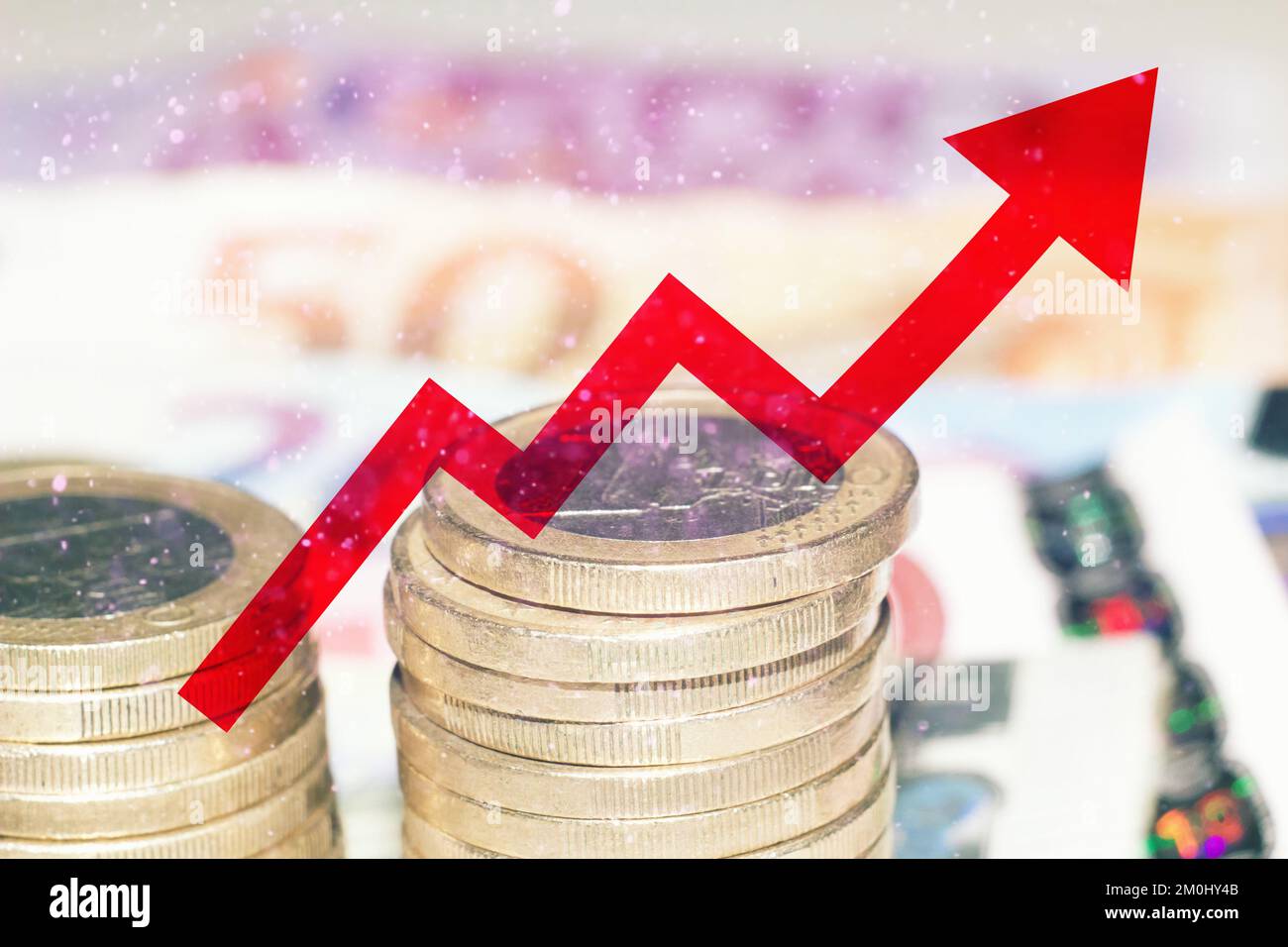 Red arrow over banknotes and euro coins, concept of increase of cost of ...