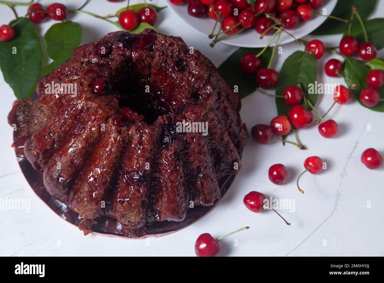 Delicious chocolate cake with sweet cherry, white plate with berry of ...