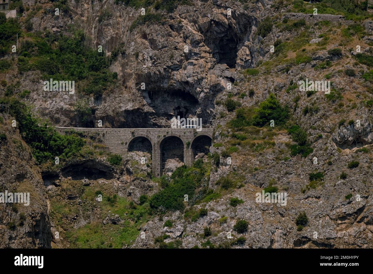 A stone bridge seen amongst the limestone cliffs of the Amalfi Drive a ...