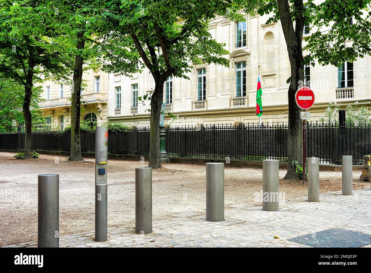 A row of Steel Bollards for Security with metal wall fence and building ...