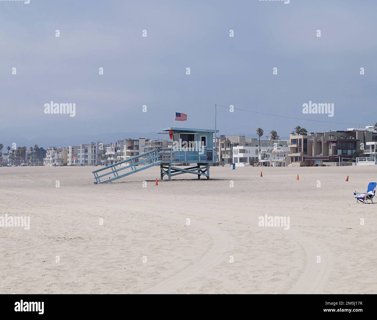 A lifeguard tower guarding beach houses within the sands of Venice ...