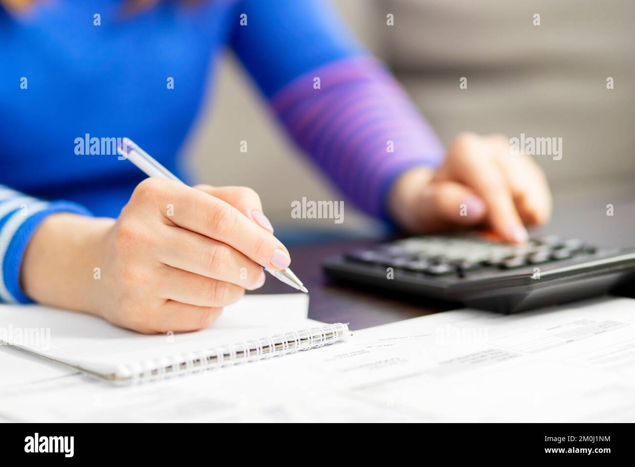 Woman using calculator for calculate domestic bills for paying taxes ...