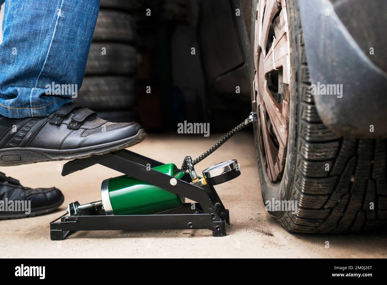 Man's foot pumping up a flat car tyre or tire, which is deflated Stock ...