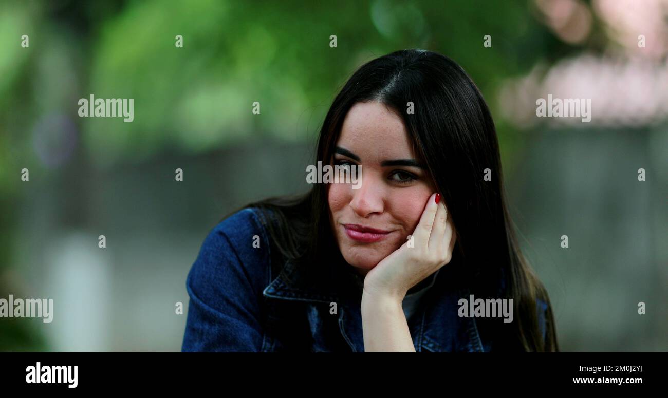Millennial woman posing at camera outside with different emotions and ...