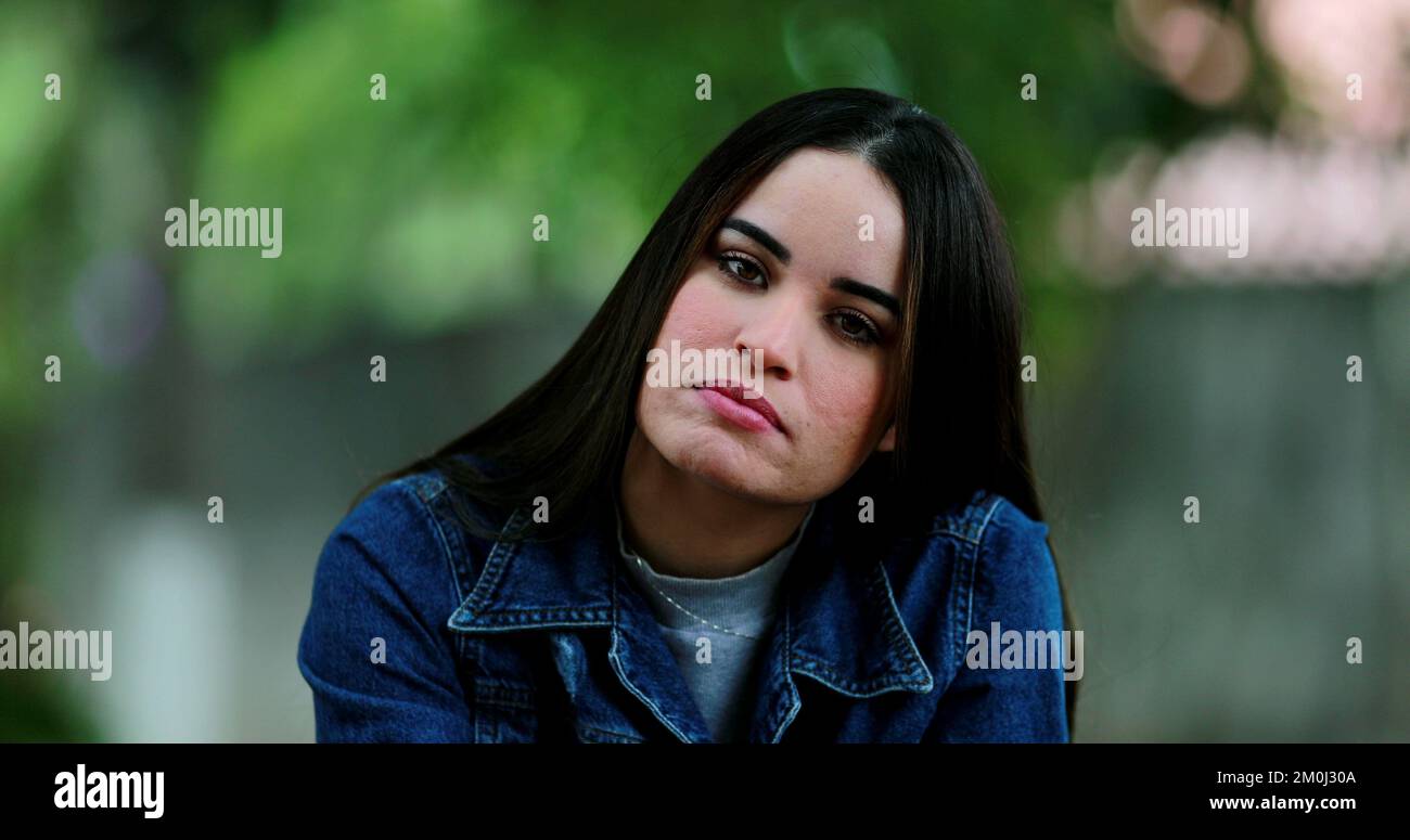 Millennial woman posing at camera outside with different emotions and ...