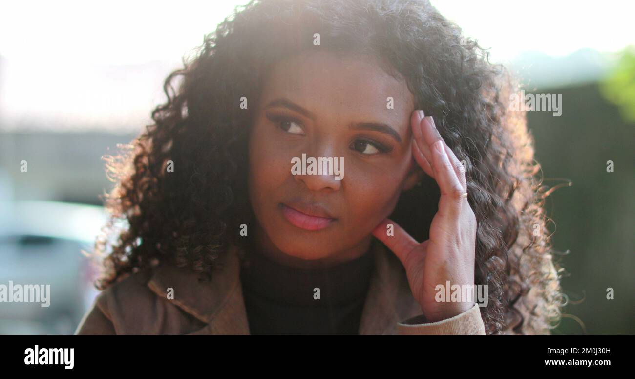 Nervous anxious young black woman standing outside fidgets with hands ...