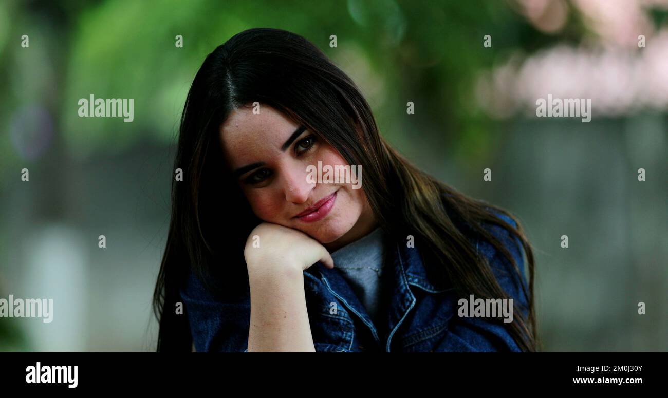 Millennial woman posing at camera outside with different emotions and ...