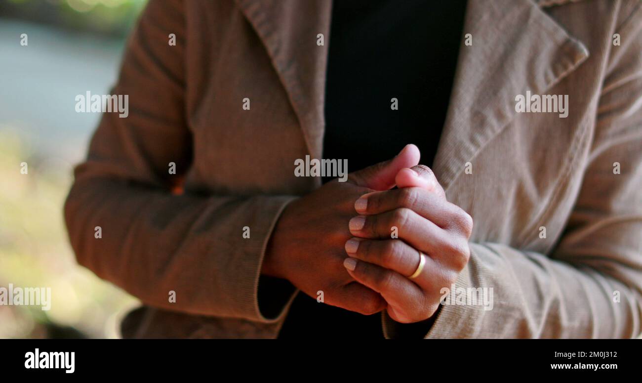 Nervous anxious young black woman standing outside fidgets with hands ...