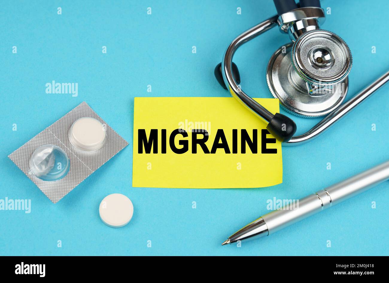 Medical concept. On a blue surface, a stethoscope, pills, a pen and a ...