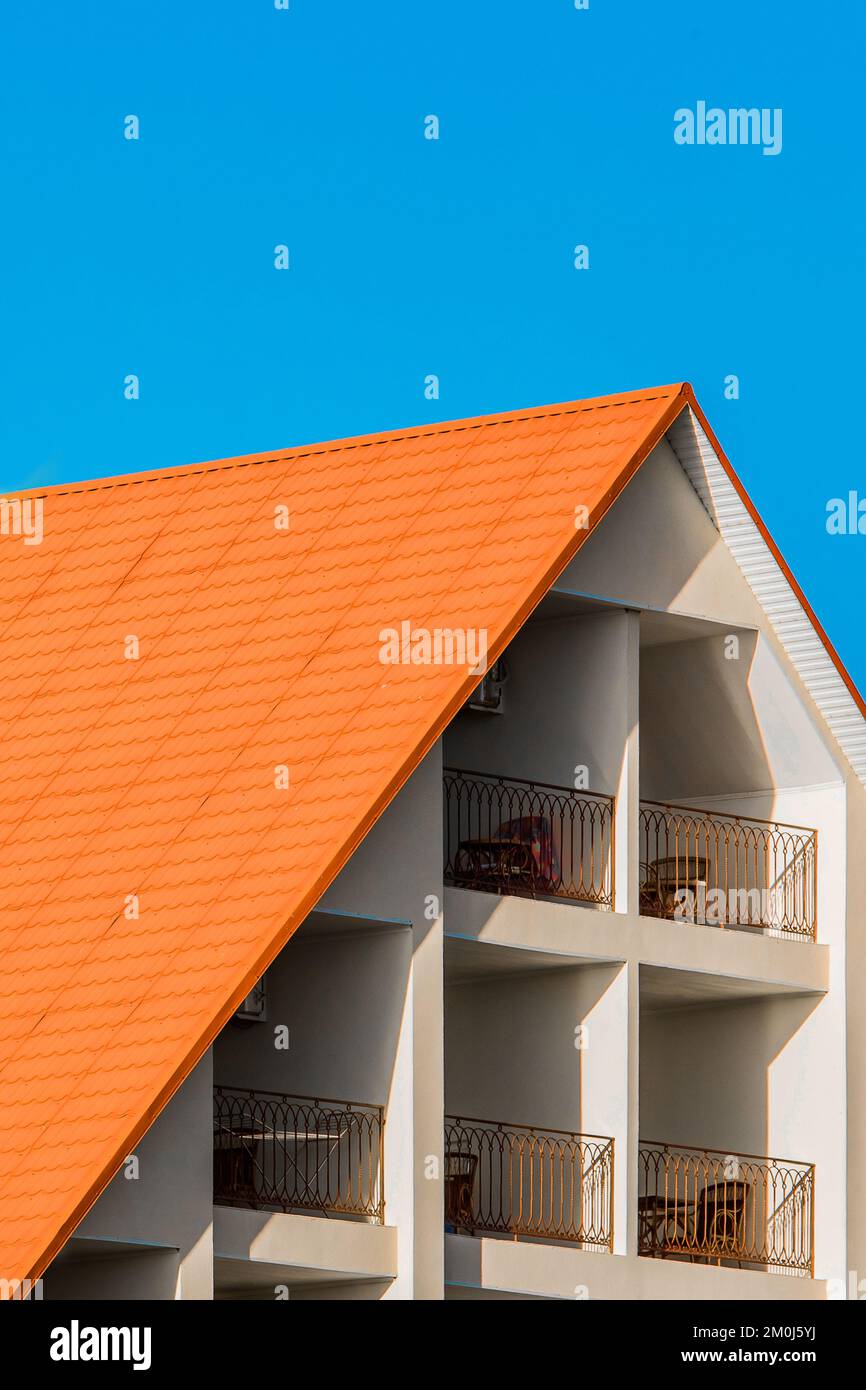 Geometric modern building facade exterior with orange tiled roof. Hotel ...