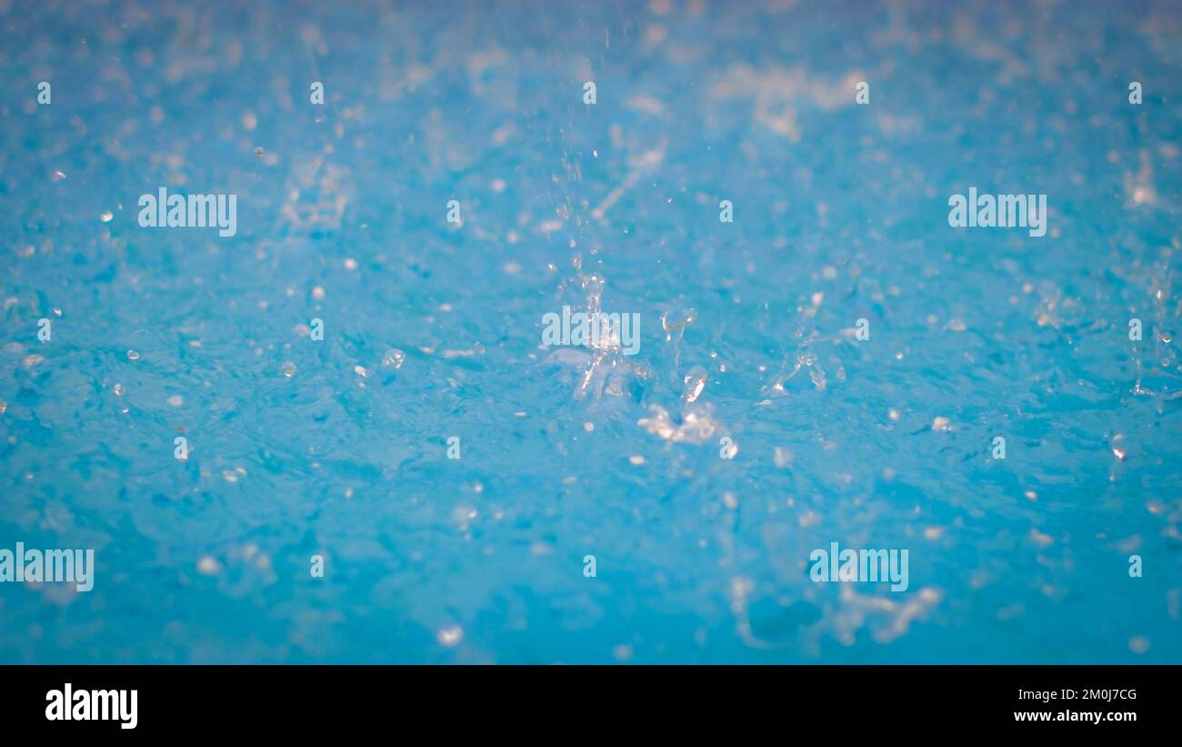 Frozen droplets. Close up of a drop. Raining on a blue swimming pool ...