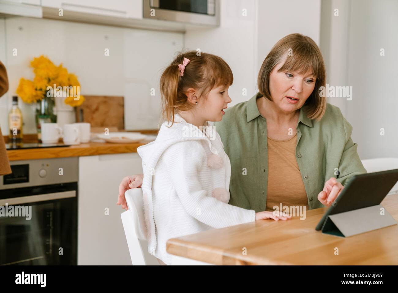 White girl using tablet computer while spending time with her ...