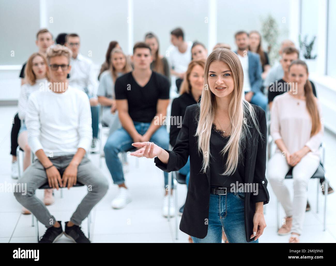 young woman standing in front of an audience in a conference room Stock ...