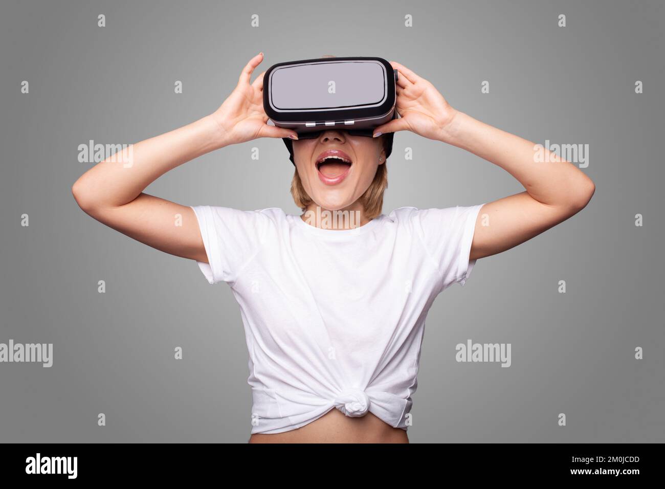 Front view of a woman wearing vr goggles headset watching on gray ...