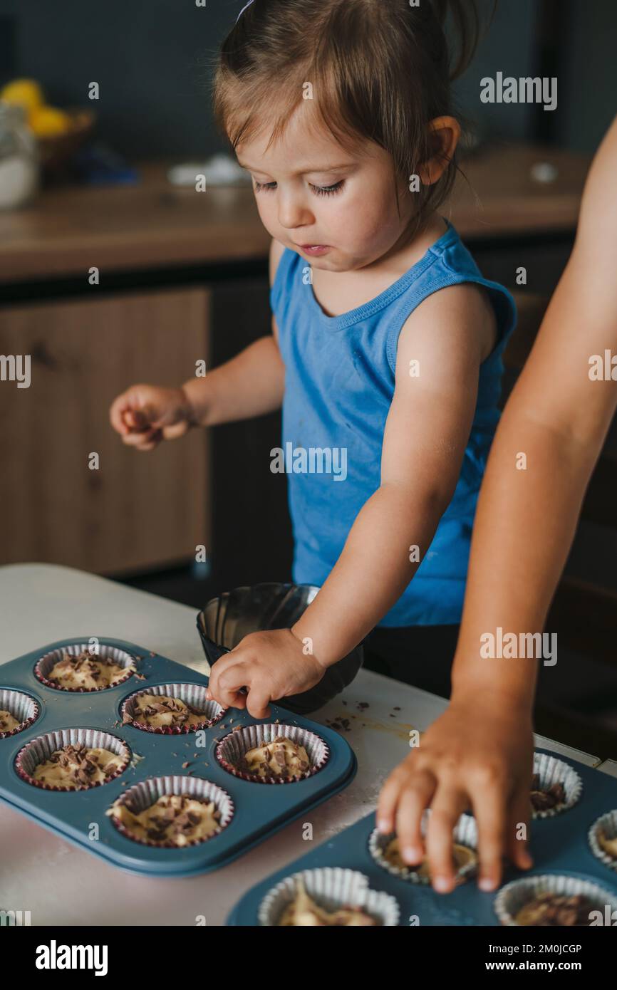 Family wirh two kids cooking muffins together. Son and daughter ...