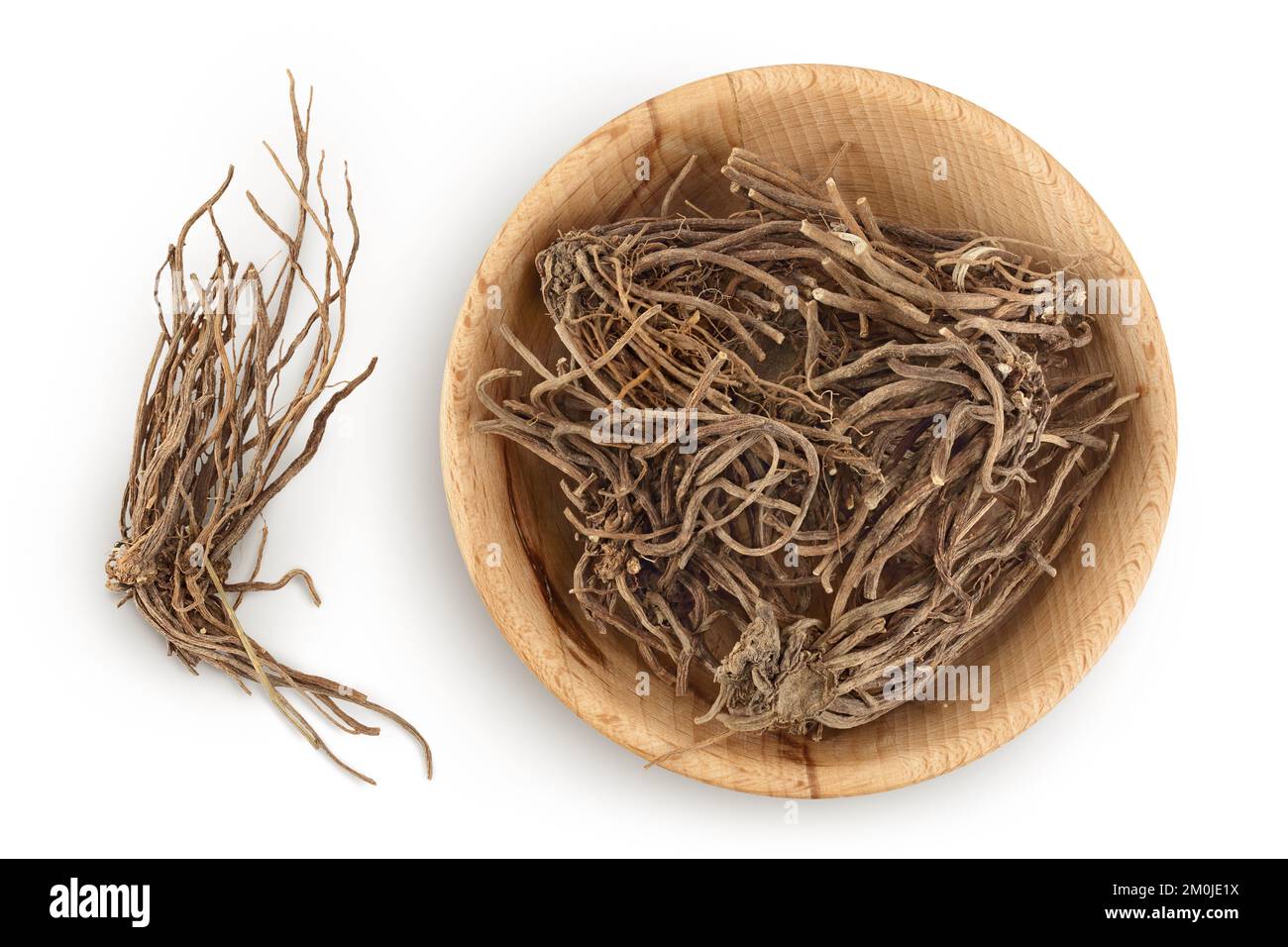Dried Valerian root in wooden bowl isolated on white background ...