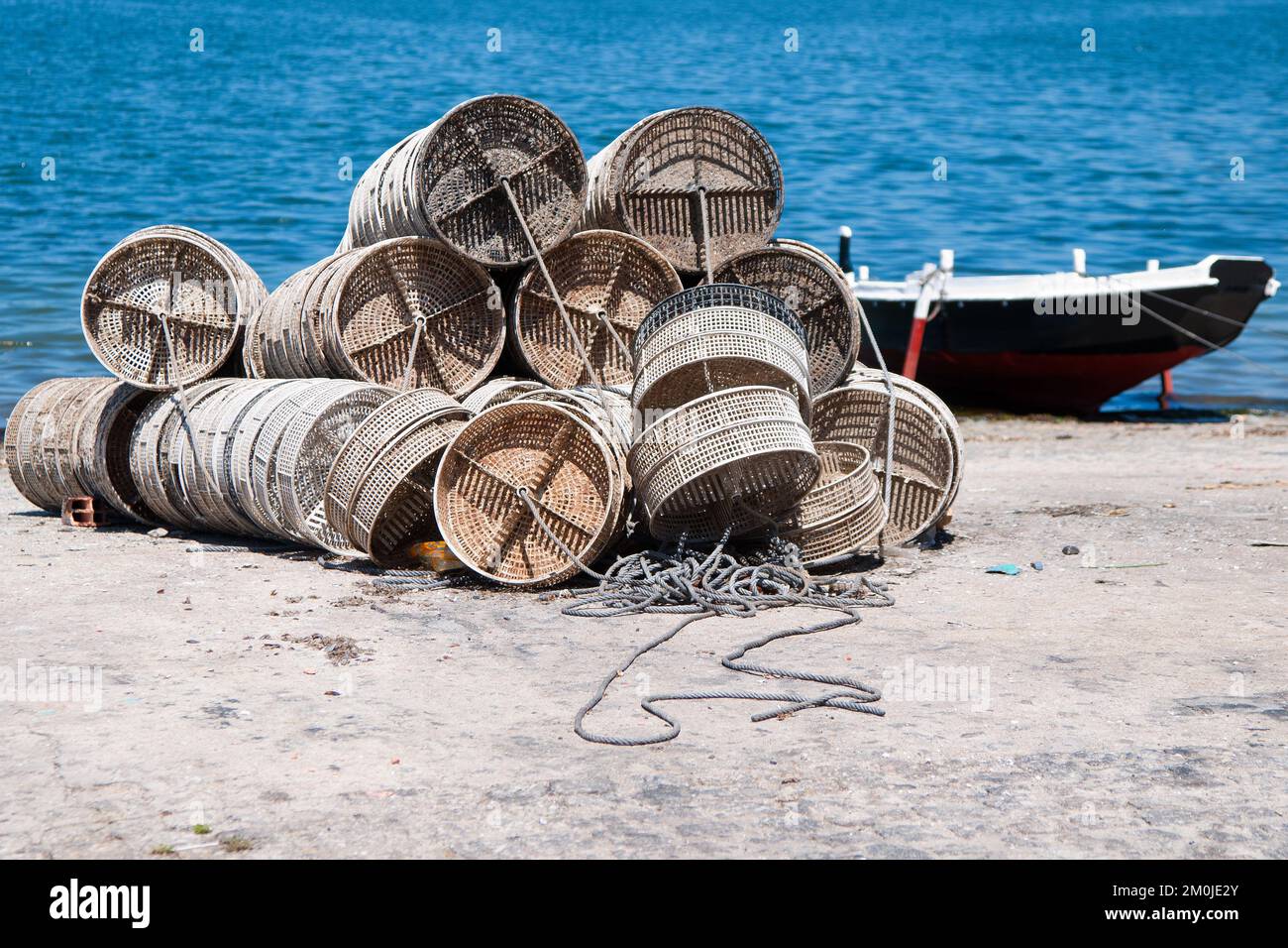 Pile of empty fishing cages. Boat on the water. Galicia, Spain Stock ...