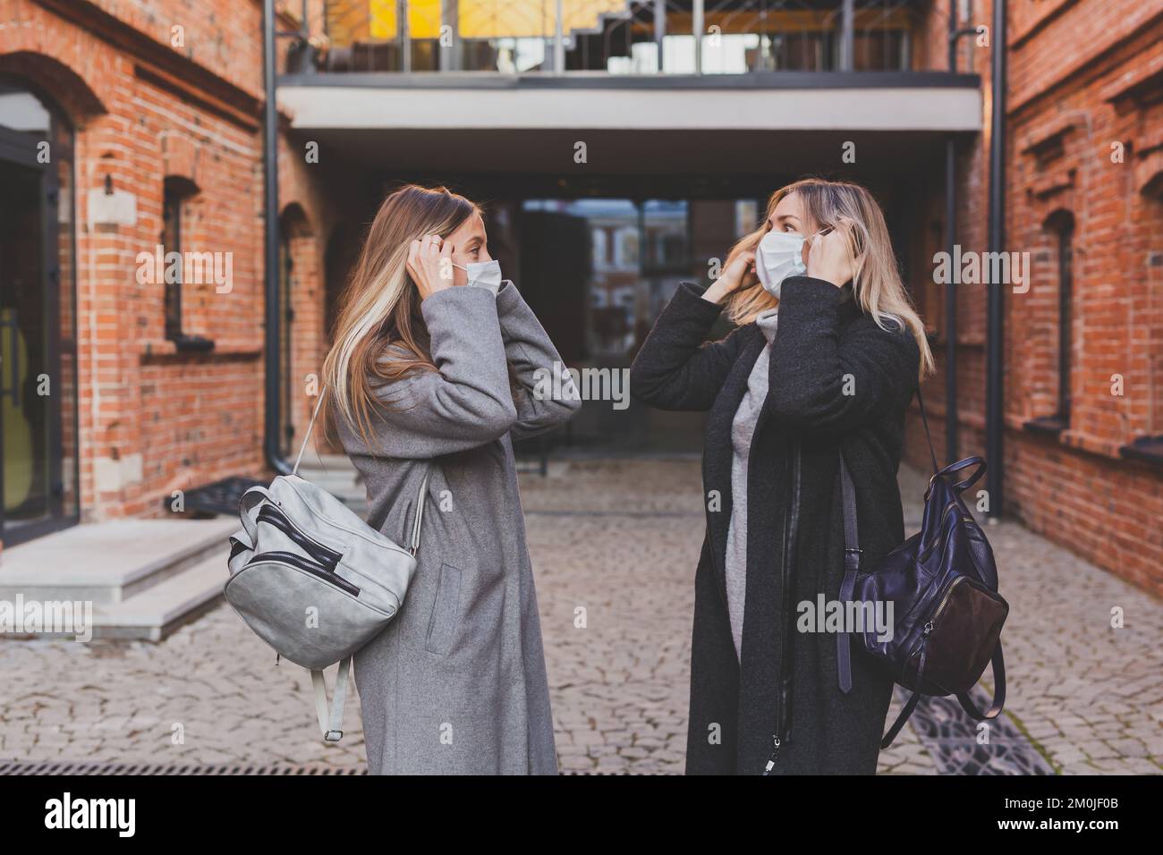 End of coronavirus pandemic. Happy women taking off medical masks ...