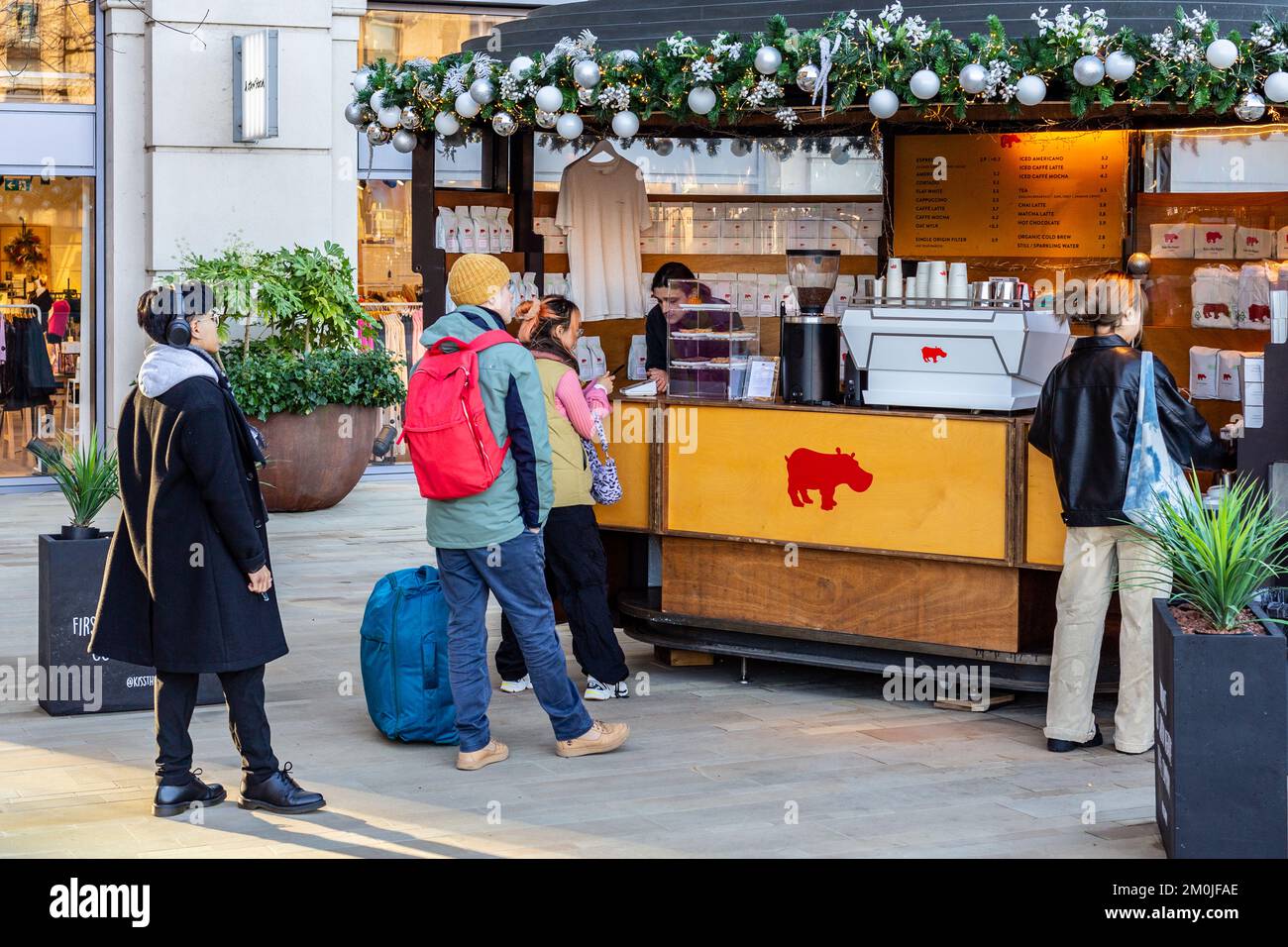 Young students in line waiting to be served with coffee.Server is ...
