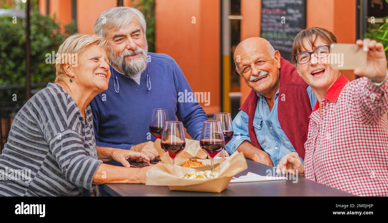 Elderly people take a selfie at the table - Mature couple have fun at ...