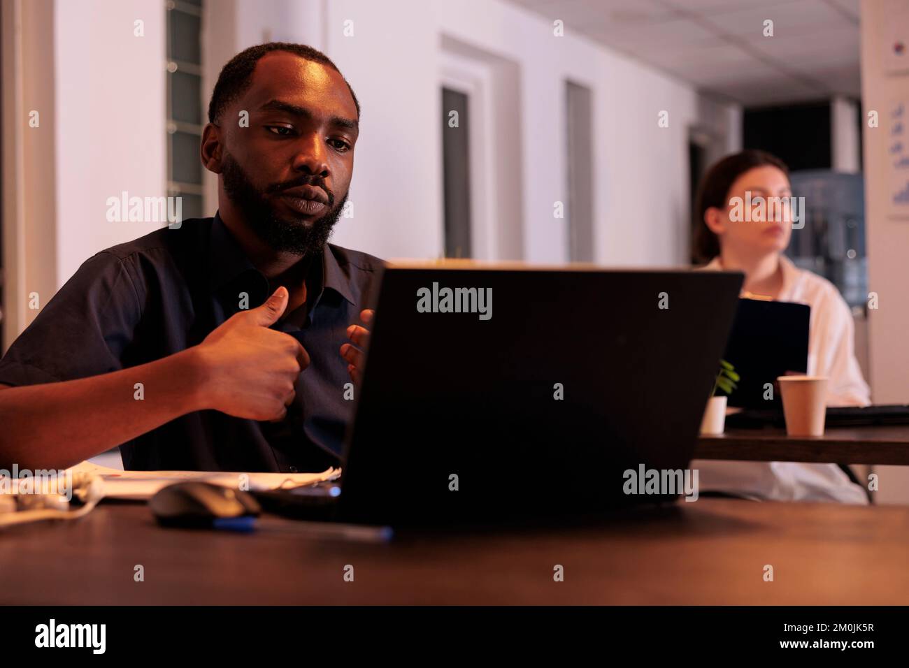 Office manager talking with colleague on videoconference on laptop ...