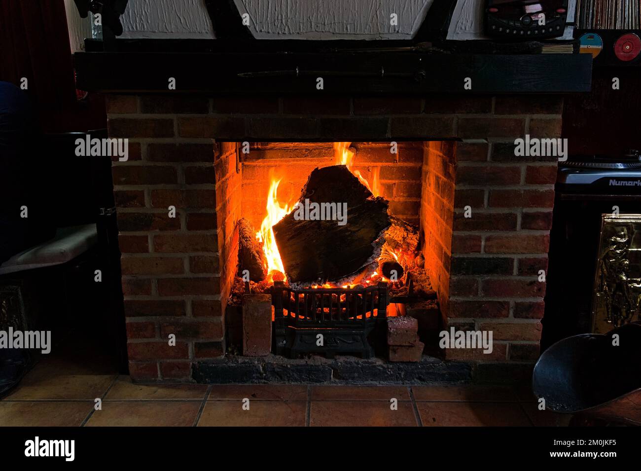 A burning log fire in a brick fireplace at the local pub Stock Photo ...