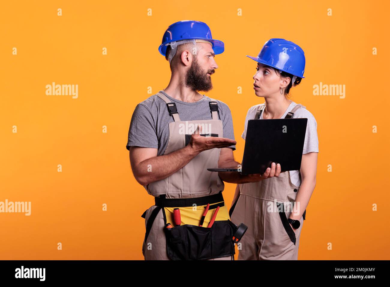 Team of constructors holding laptop and browsing internet online ...