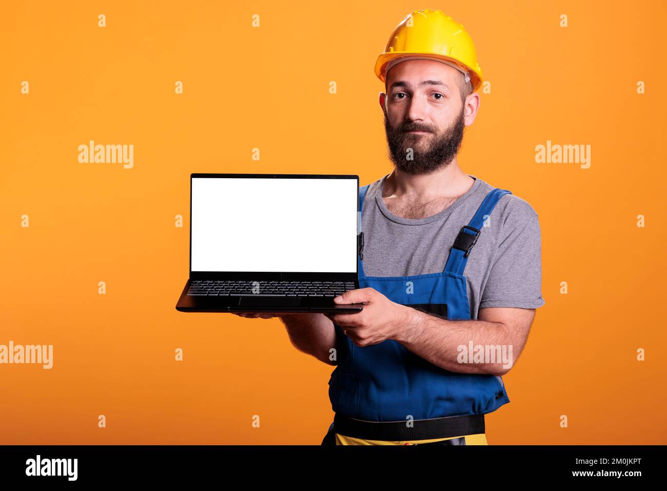 Happy craftsman expert showing laptop with white screen, holding pc ...