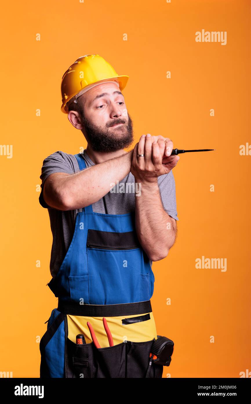 Construction worker using screwdriver to screw nails, carpenter dressed ...