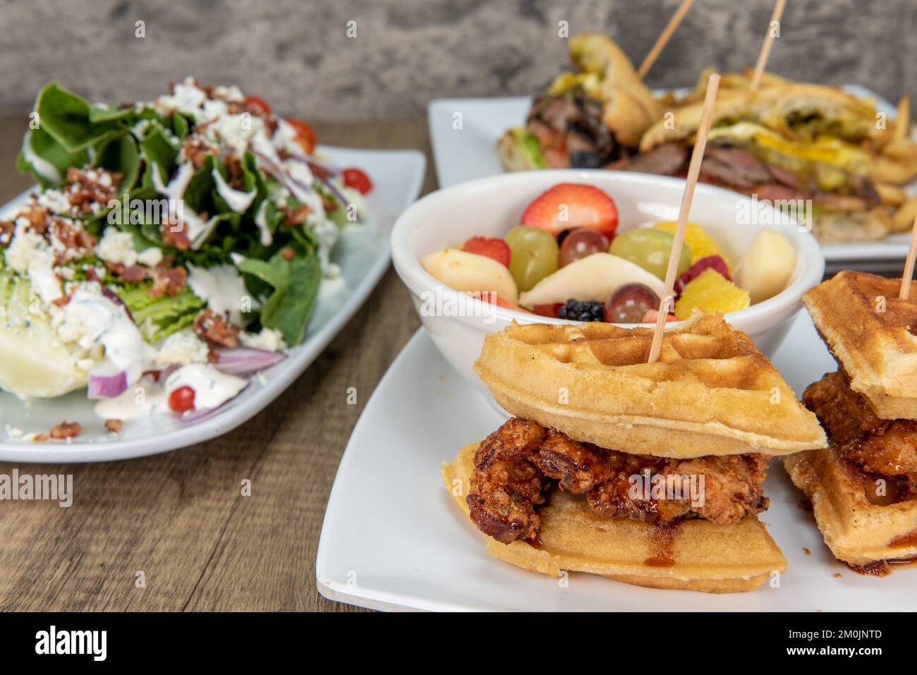 Amazing feast on the table with chicken and waffles, romaine salad, or ...