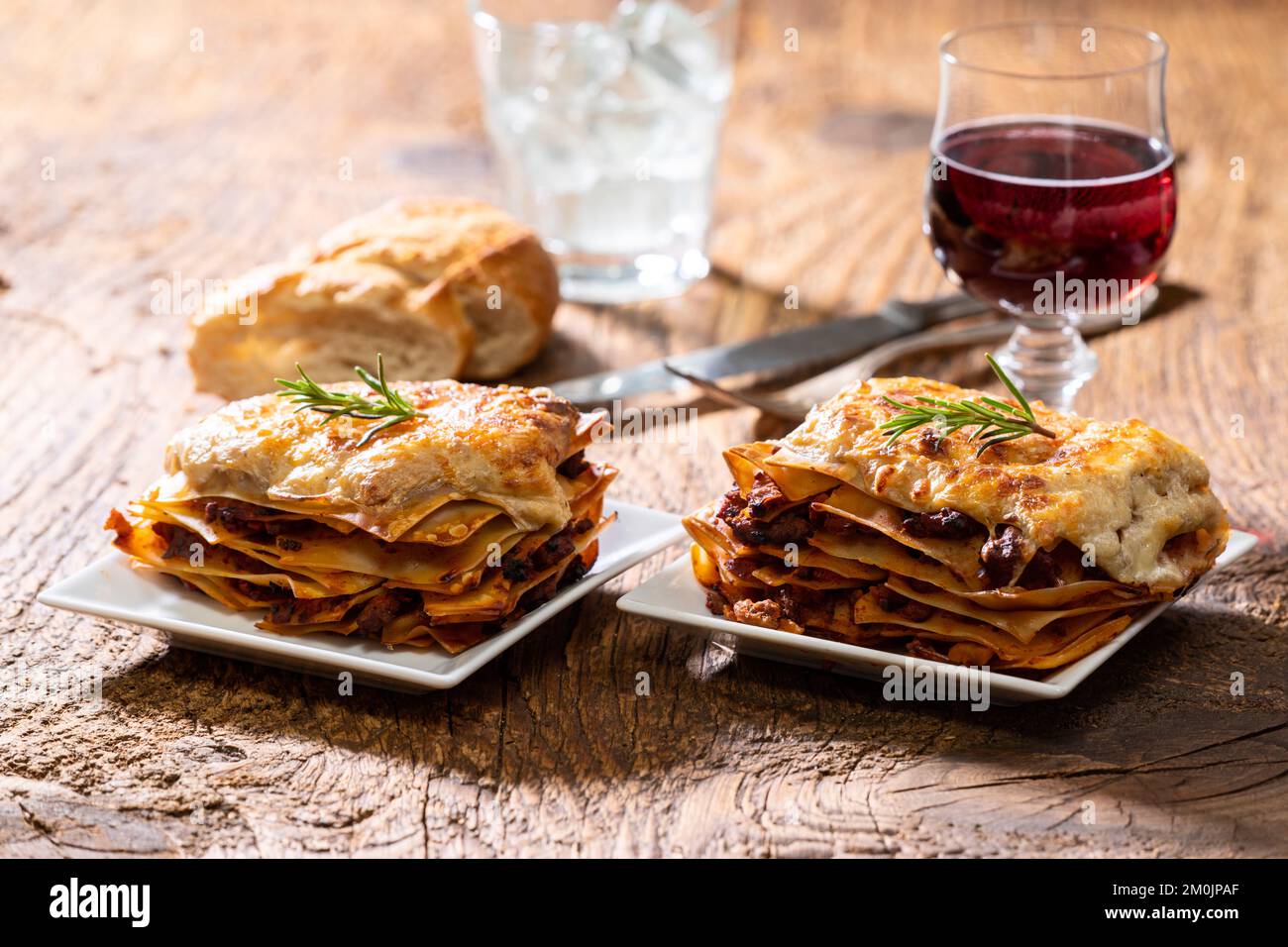 two portions of lasagna on wood Stock Photo - Alamy