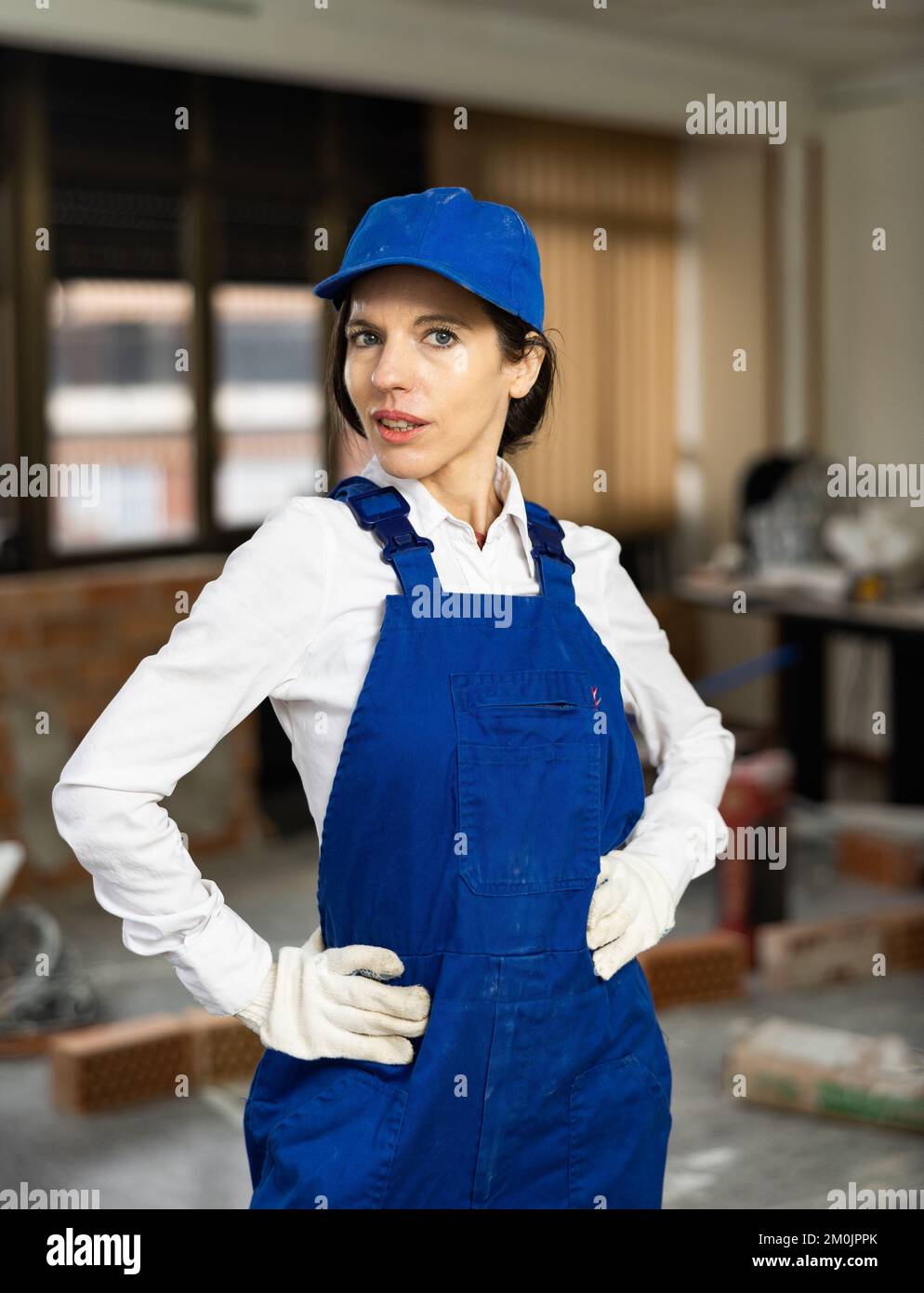 Woman construction worker posing inside house under renovation Stock ...