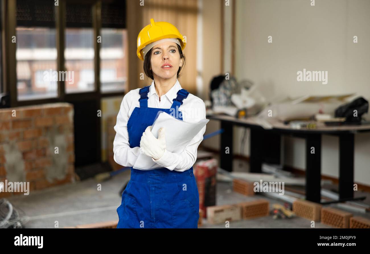 Female contractor taking notes while planning renovation works in ...