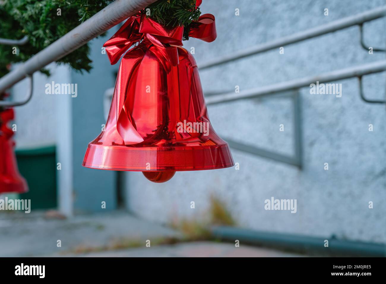 One large Christmas red bells with red bow and pine leaves, street ...
