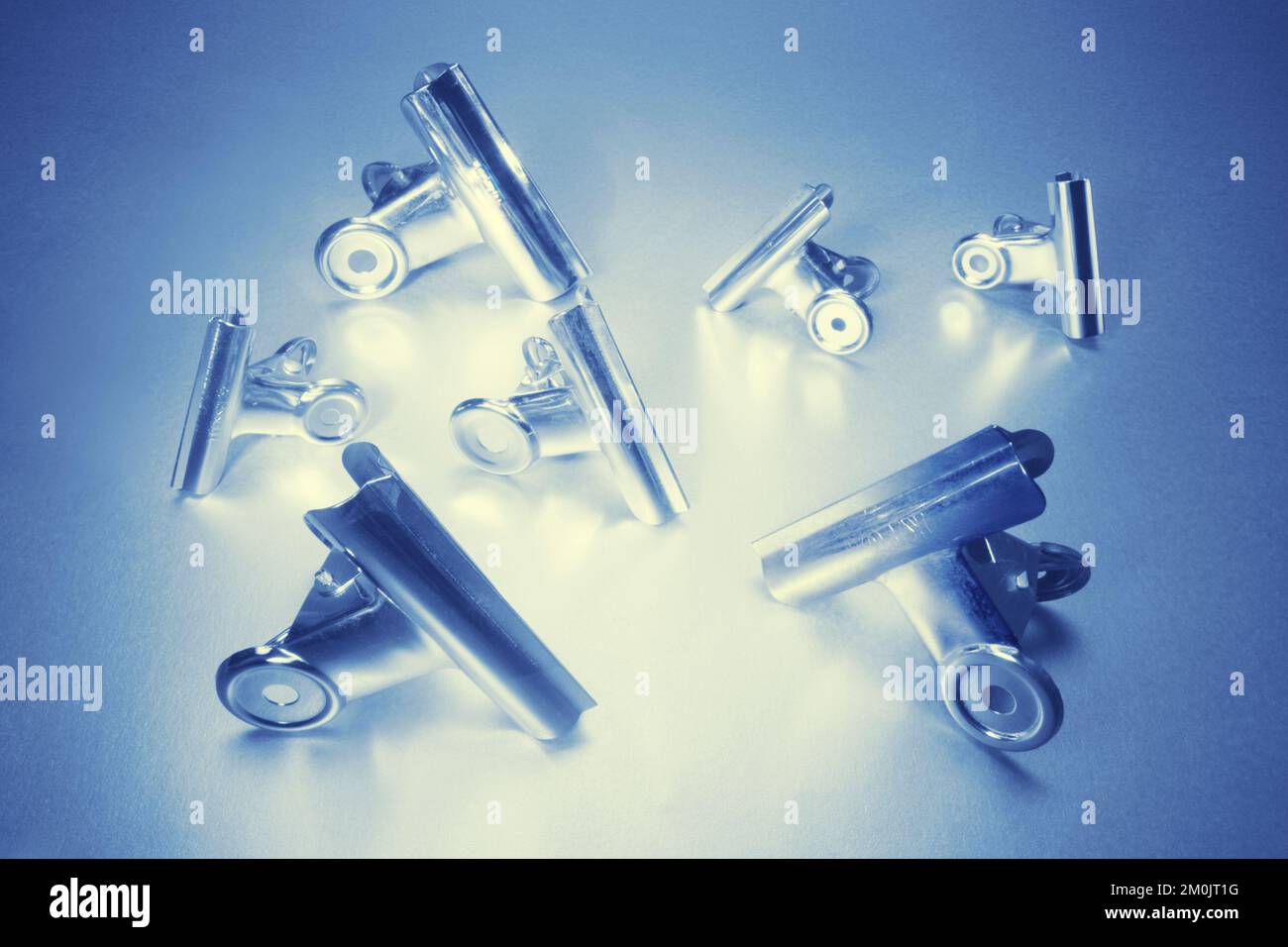 Bulldog Clips on Blue Background Stock Photo - Alamy