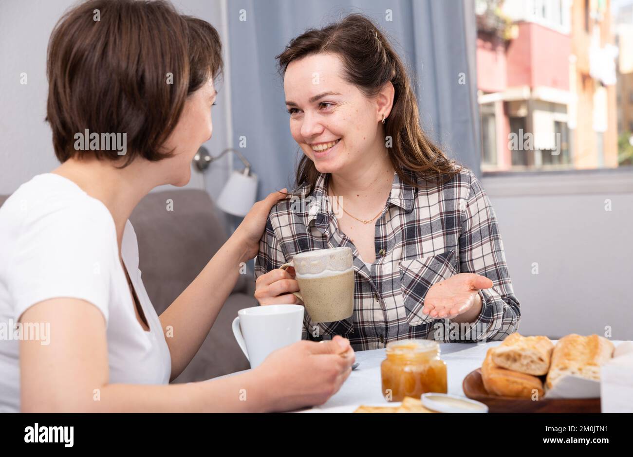 Two woman friends talking and drinking tea in the kitchen Stock Photo ...