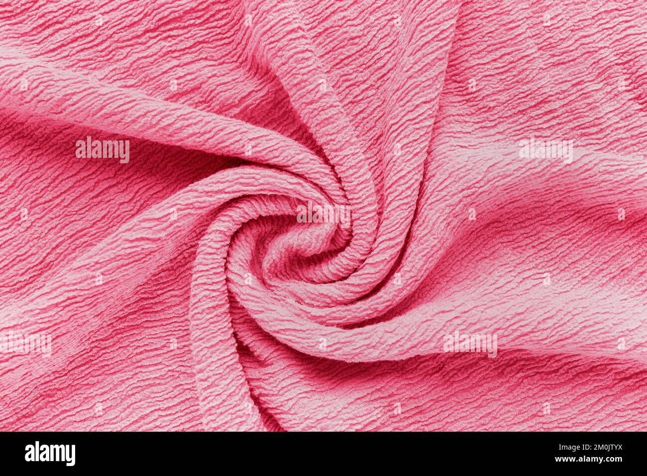 Soft pink fabric with puckered texture twisted in spiral. Abstract ...