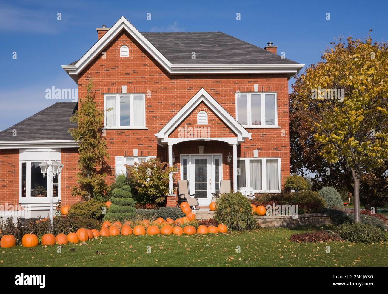 Contemporary red brick with white trim two story home decorated with ...