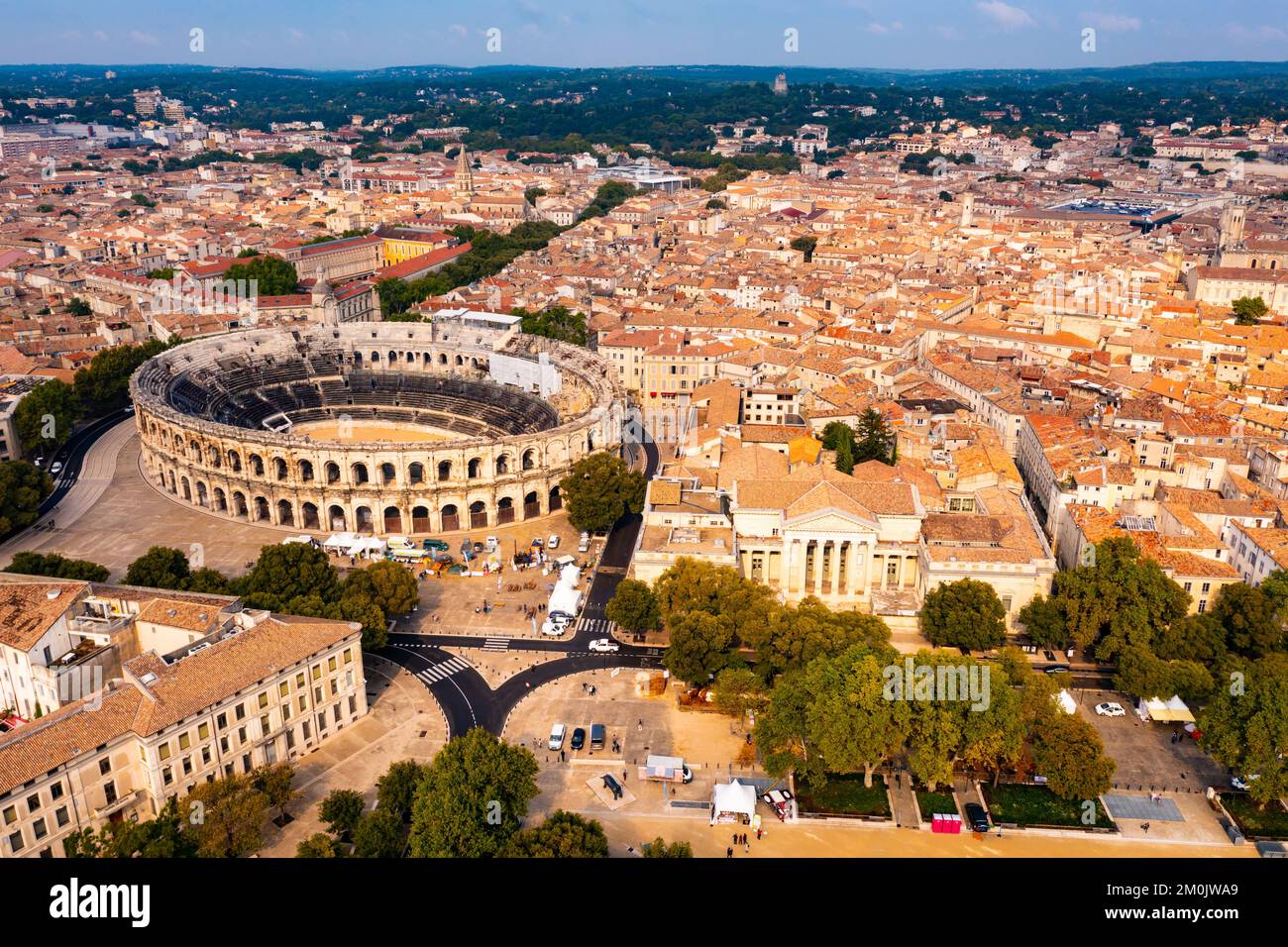 Aerial view of Roman amphitheatre on background with cityscape of Nimes ...
