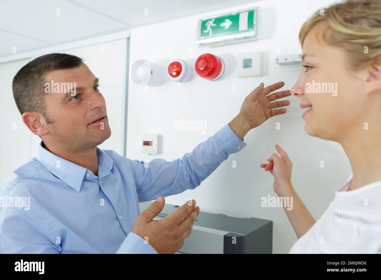 man and woman worker checking fire alarm Stock Photo - Alamy