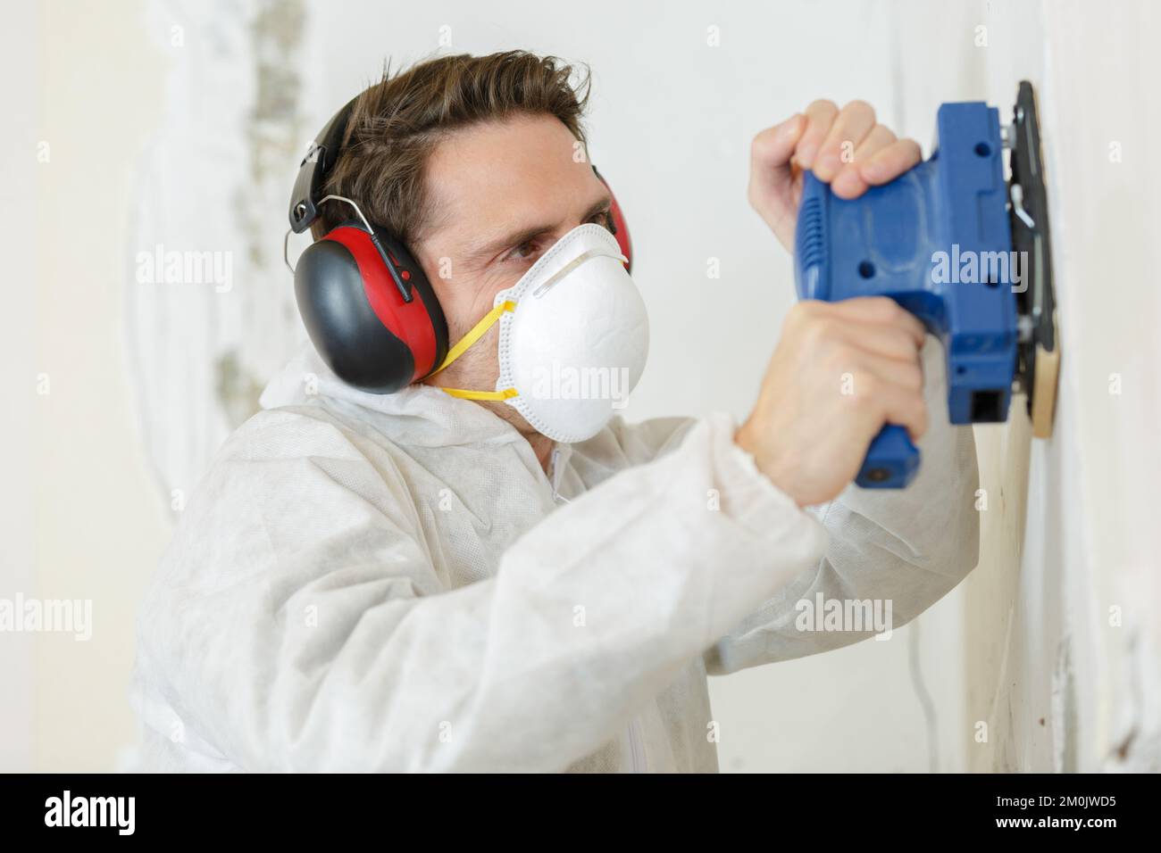 Young contractor sanding wall hi-res stock photography and images - Alamy