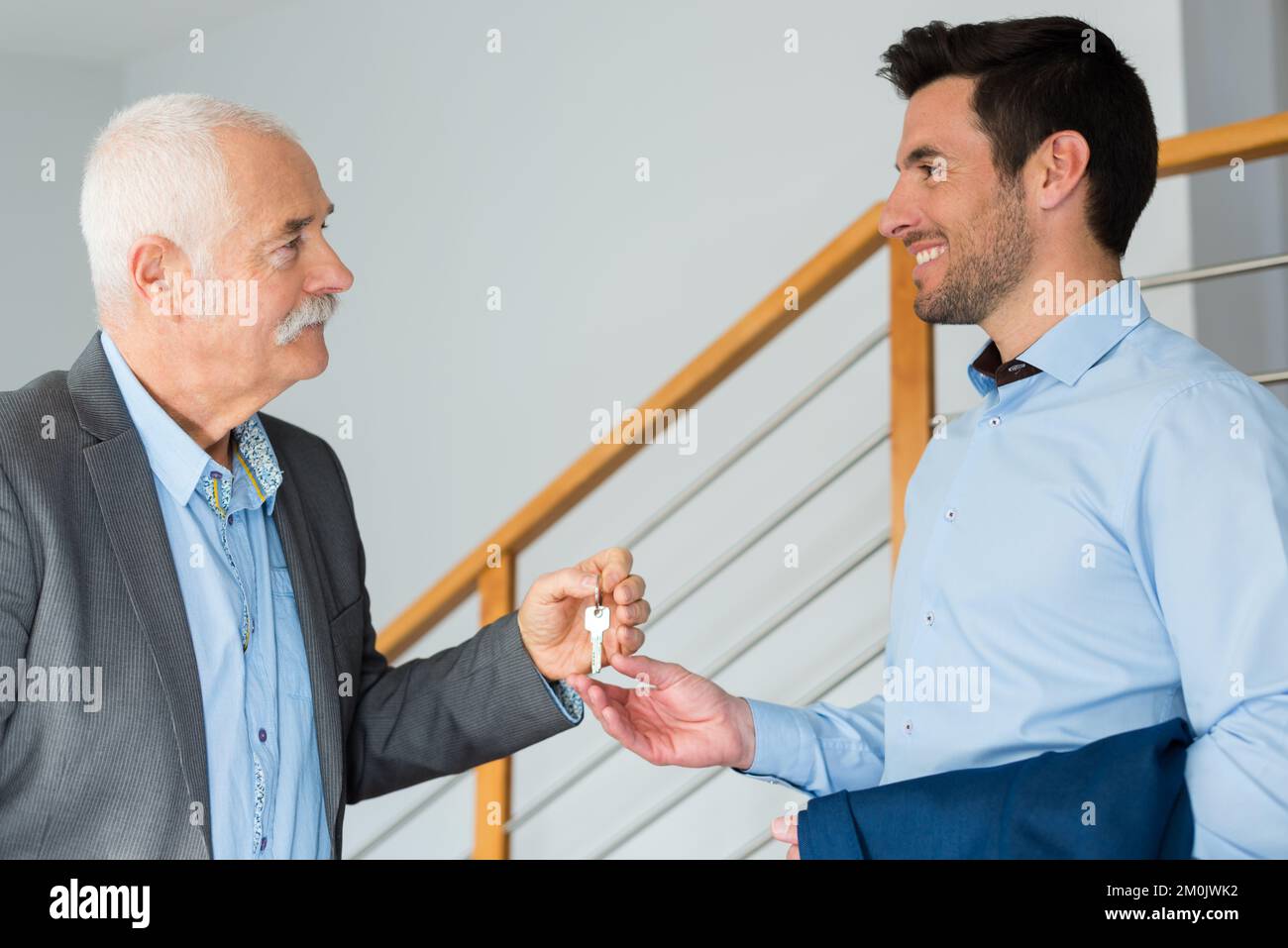 elderly man giving key to the younger man Stock Photo - Alamy