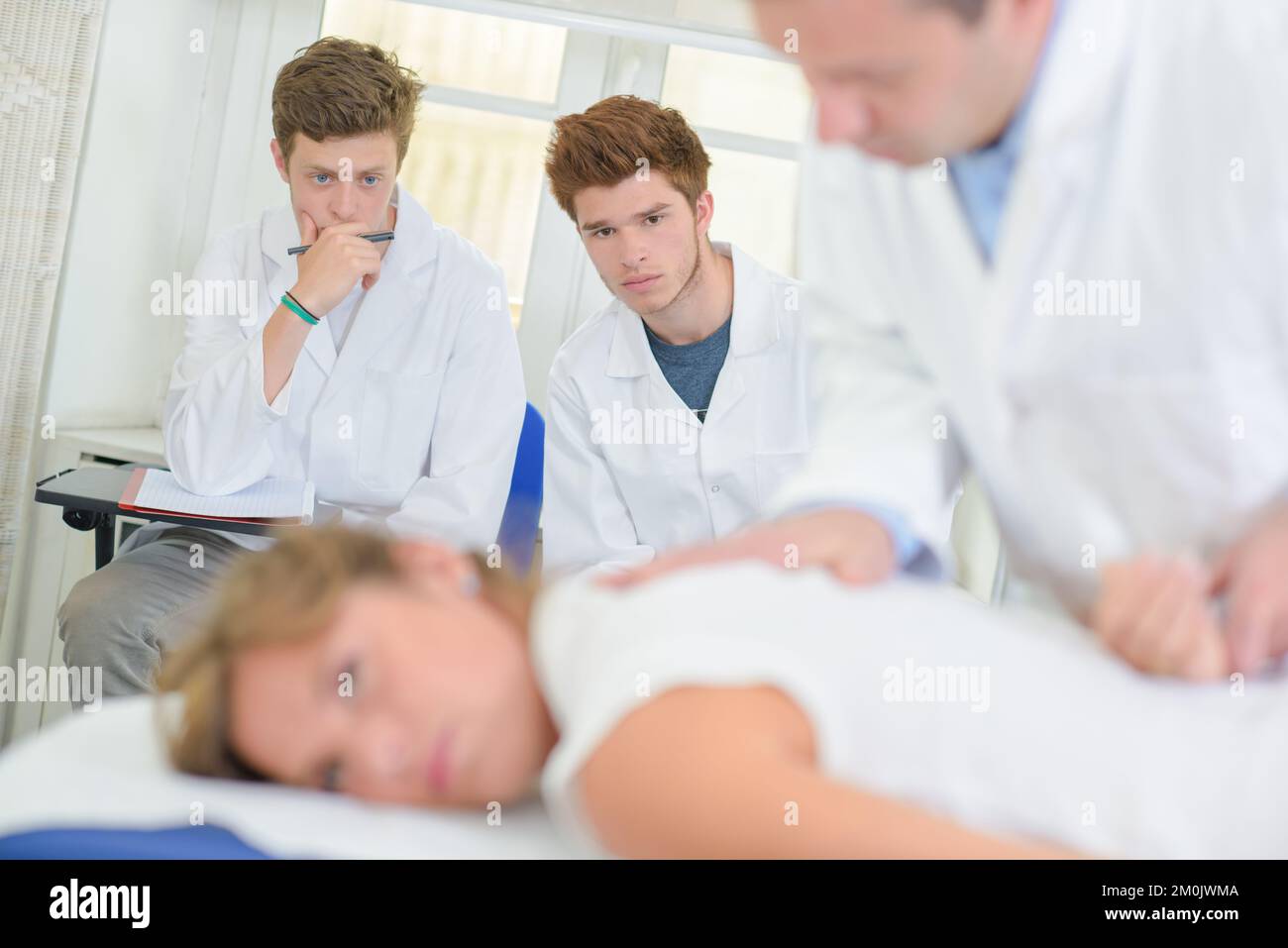 Doctor working on patient's back, students observing Stock Photo - Alamy