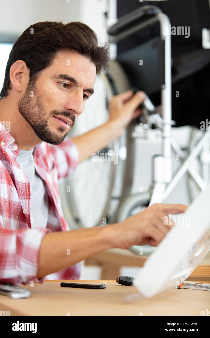 Young man repairing wheelchair hi-res stock photography and images - Alamy