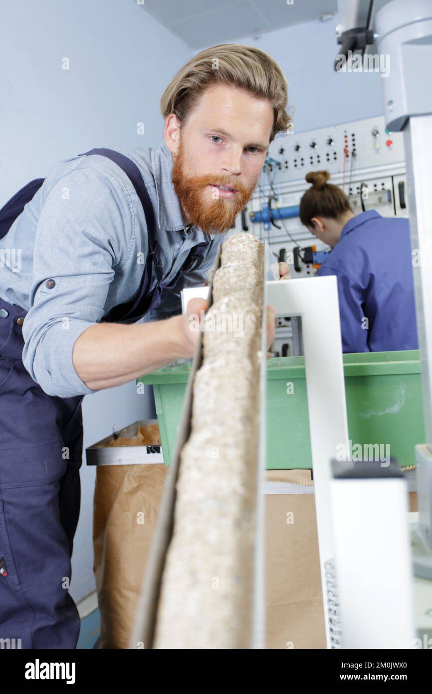 young mechanical worker looking at machine Stock Photo - Alamy