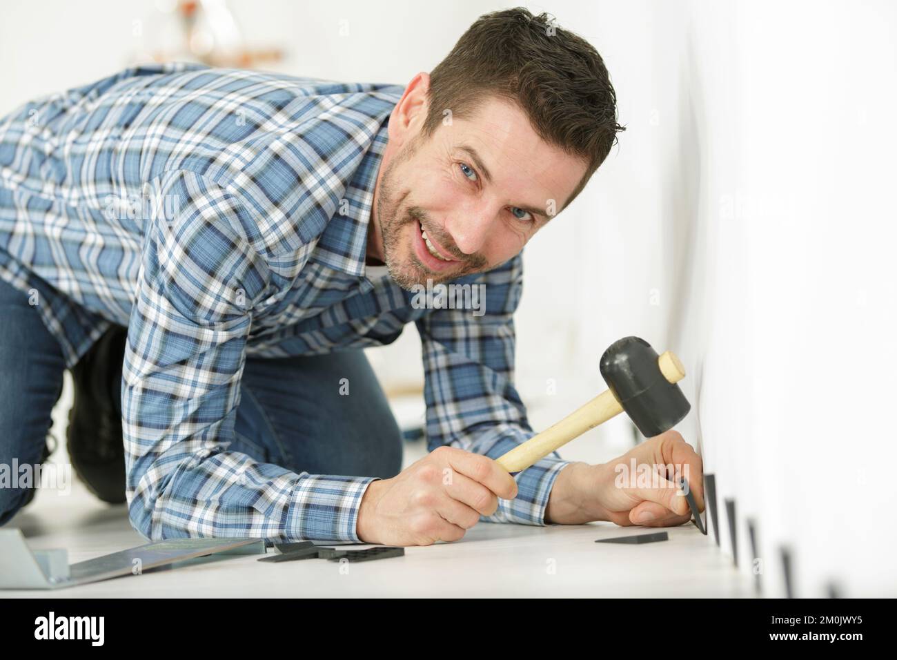 a handyman installing wooden floor Stock Photo - Alamy